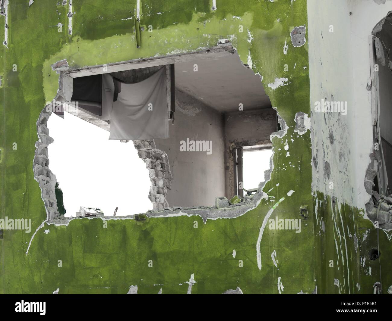 green broken demolished house with a big hole in the wall Stock Photo ...