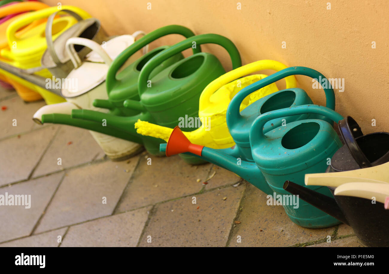 watering cans of many colors and many shapes in the garden of a ...