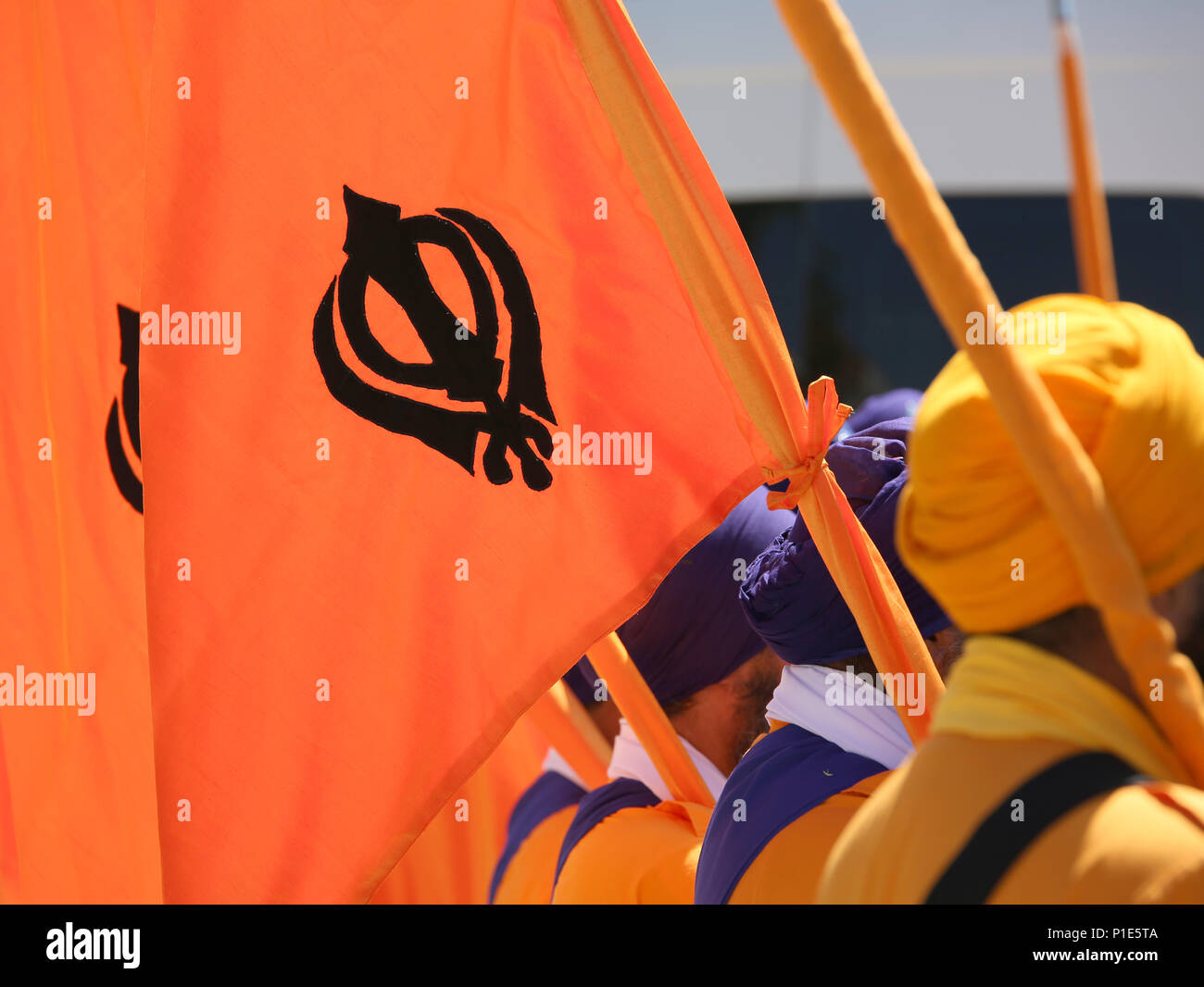 orange flag with symbol of the Sikh religion called KHANDA formed by ...