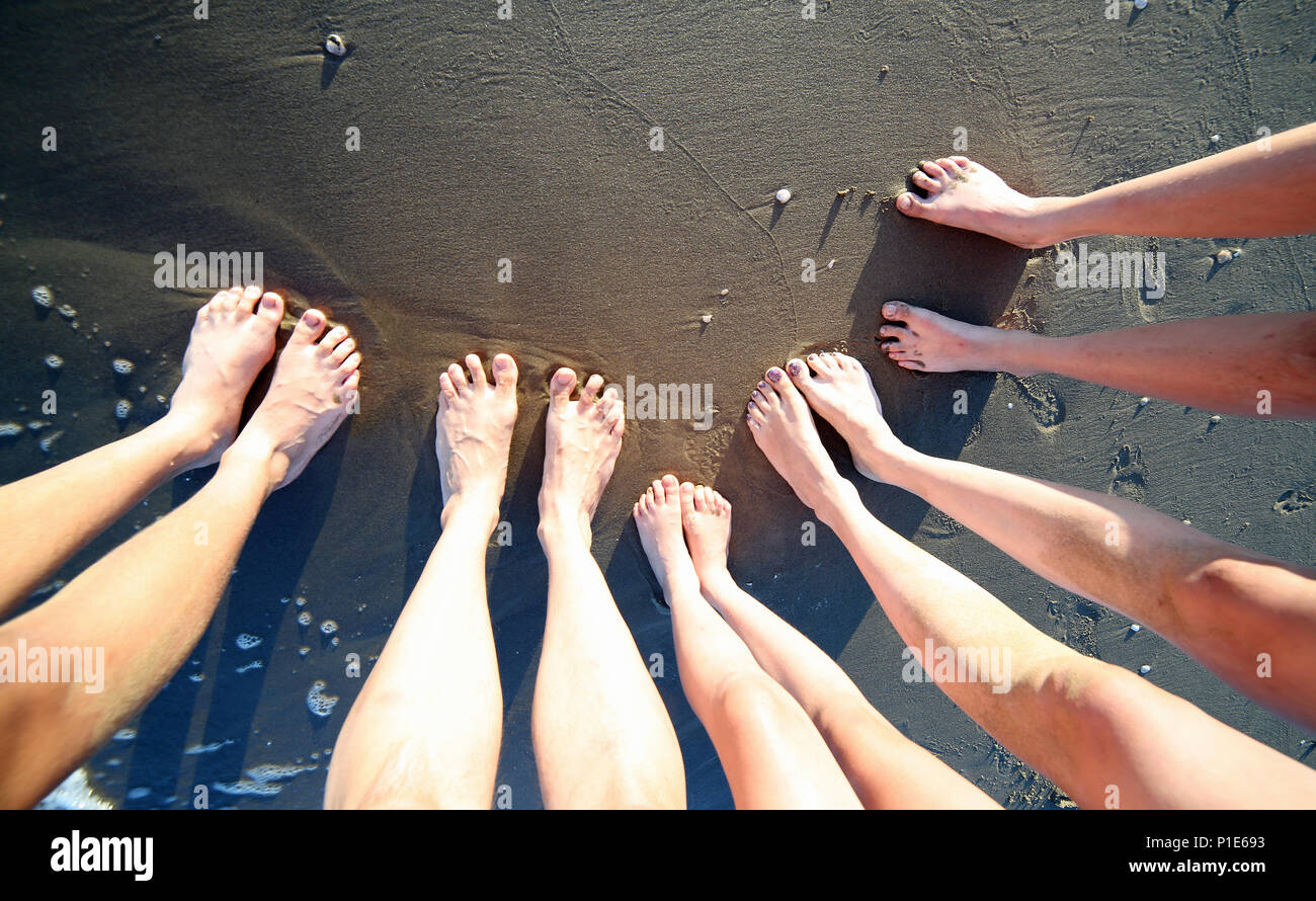 ten feet of a family of five barefoot people on the seashore in the ...