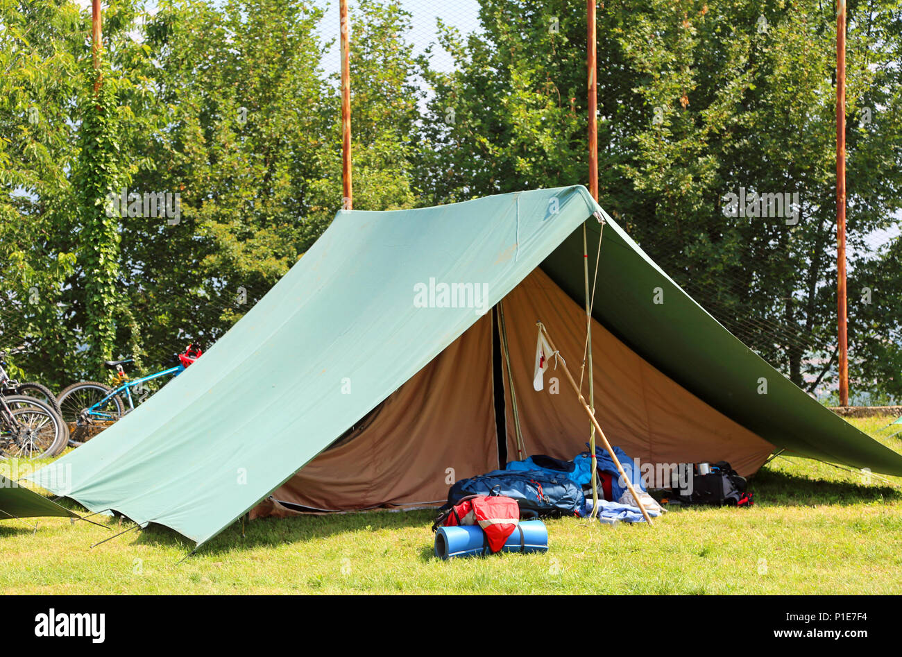 small green scout tent on a lawn with a few backpacks outside Stock ...