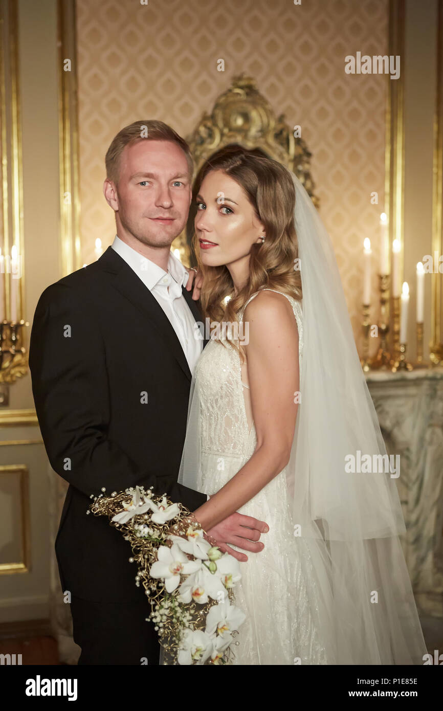 Wedding couple in a luxurious interior in the Baroque style is hugging ...