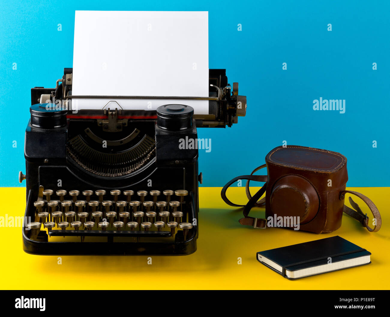 Vintage typewriter with empty, blank sheet of paper, camera and ...
