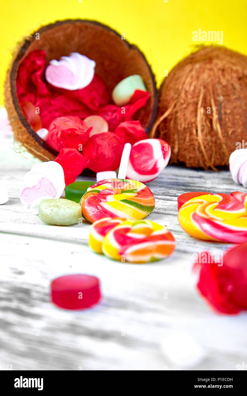 Explosion of candies from coconut on yellow paper background. Copy ...