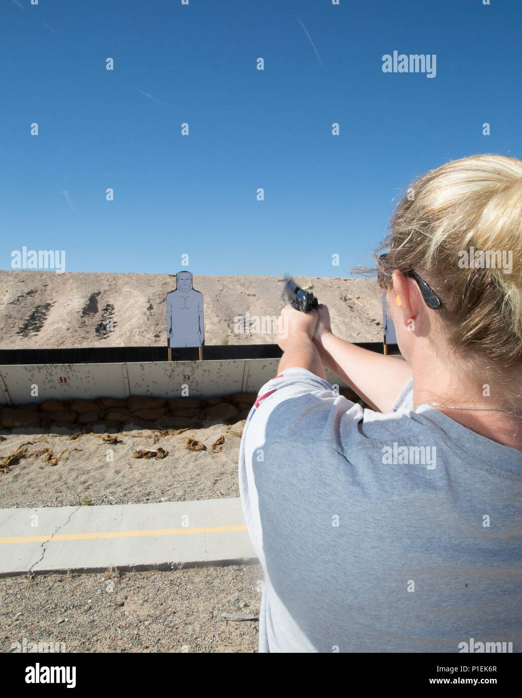 Jill Kovach fires a round at her target during the shooting portion of ...