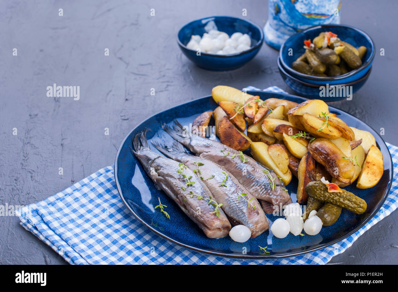 Herring fillets on a plate, baked in the oven potatoes and pickles ...