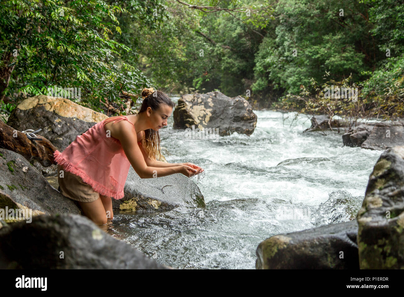 A young girl drinks water from a mountain stream Stock Photo - Alamy