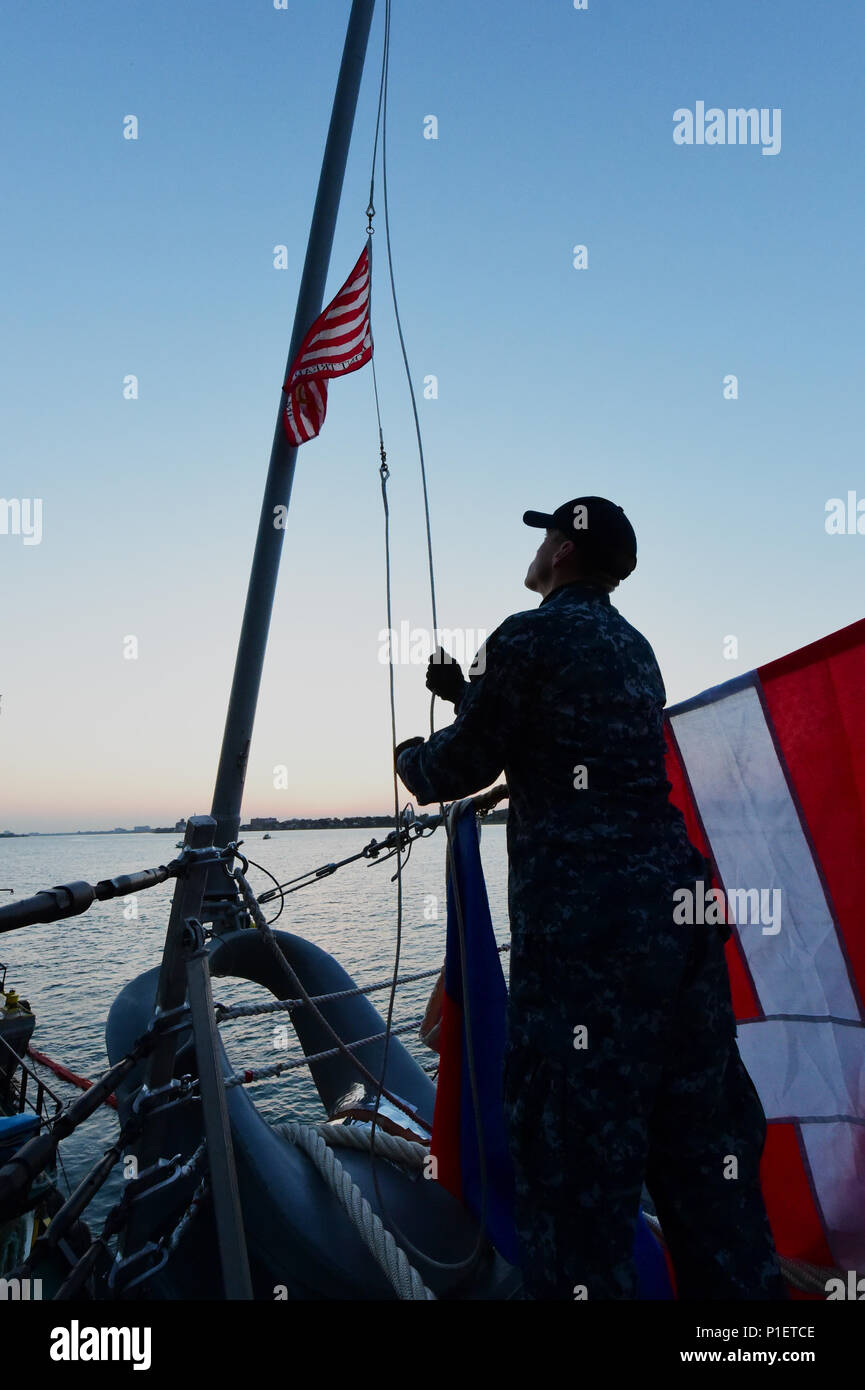 Petty Officer 1st Class Scott Morehouse raises the Navy Jack on the USS ...