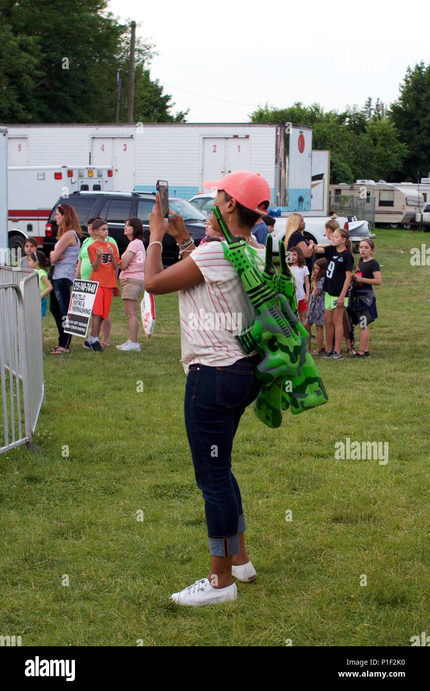 Wyndmoor, PA, USA - June 8, 2018: A mother carries her sons' inflatable ...
