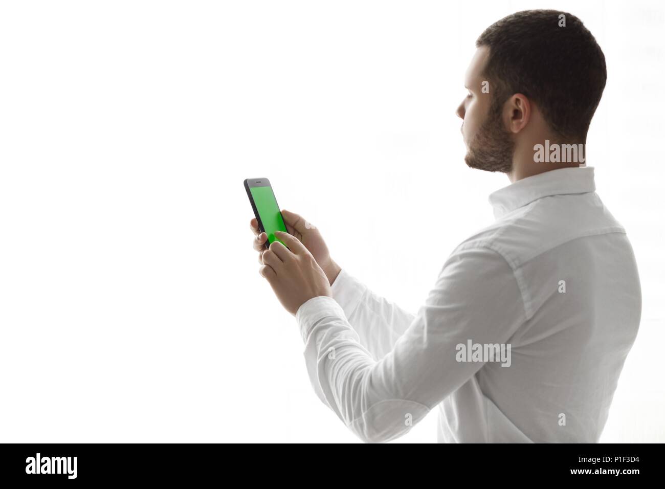 Man using mobile phone while standing near window. Chroma key Stock ...