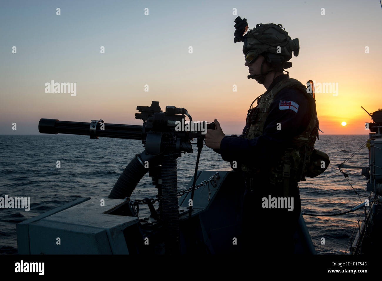 161021-N-SB587-1064 A sailor with the Royal navy mans a M134 minigun ...