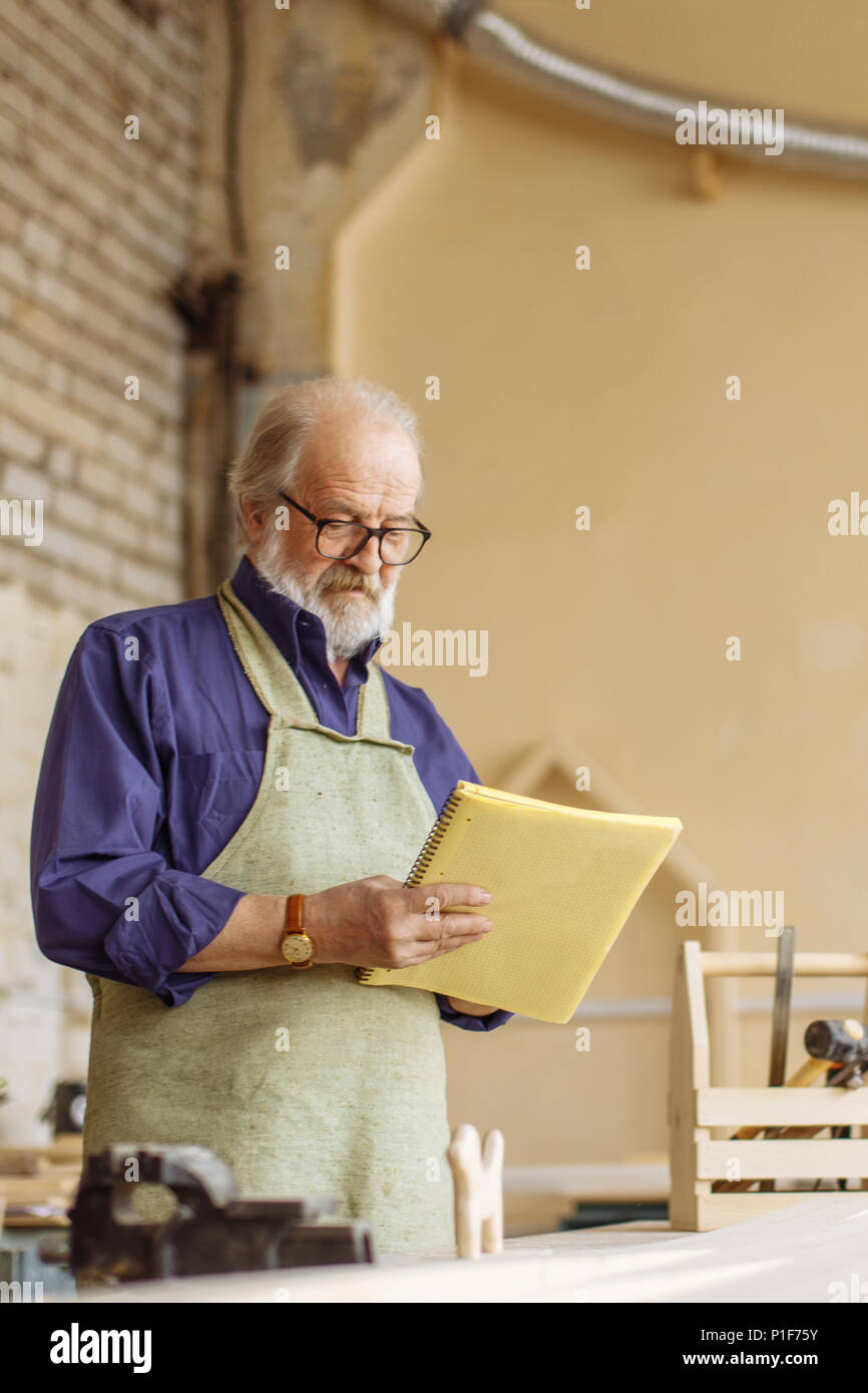 close-up side view shot of elderly man holding exercise book in his ...
