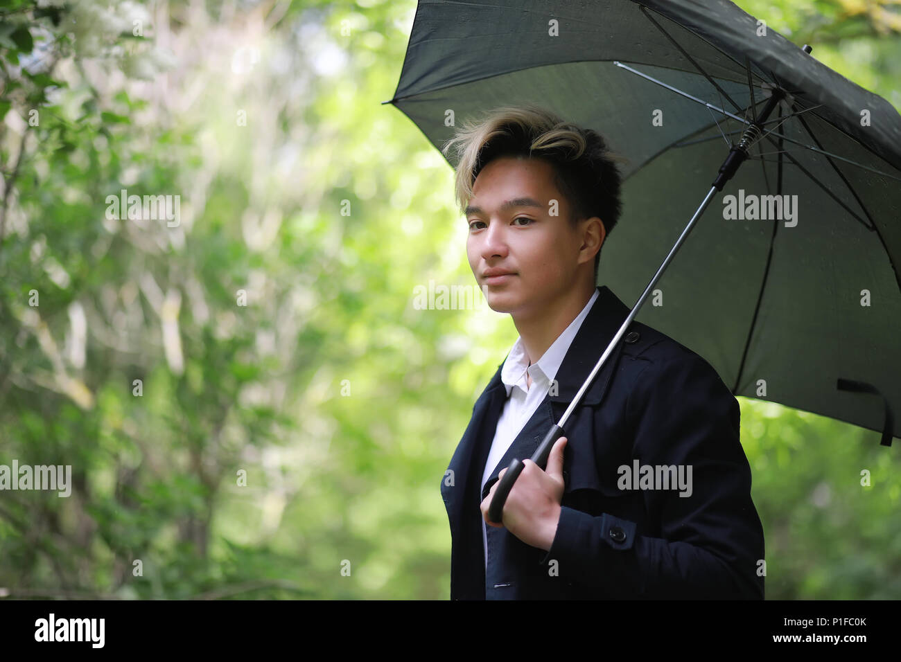 Spring Park in rainy weather and a young man with an umbrella Stock ...
