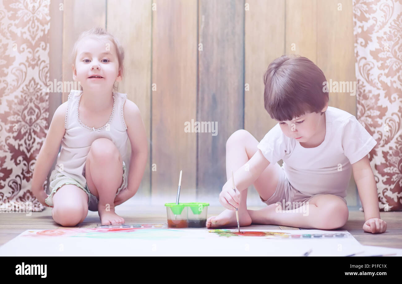 Little children paint on a large sheet of paper on the floor Stock ...