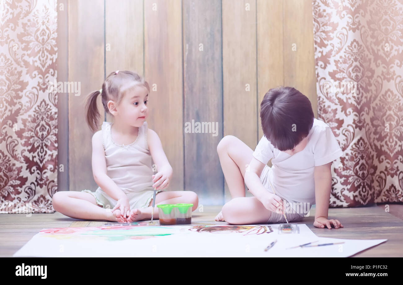 Little children paint on a large sheet of paper on the floor Stock ...