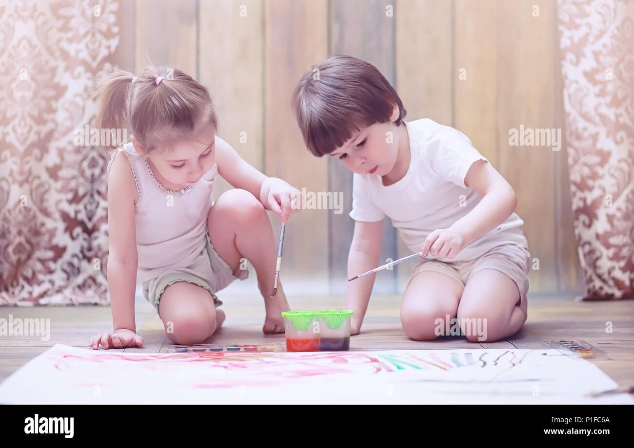 Little children paint on a large sheet of paper on the floor Stock ...