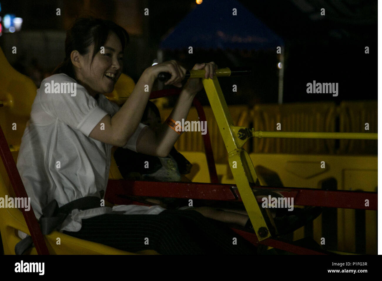 Okinawa residents laugh as they ride “The Wizzer” during Kinser ...