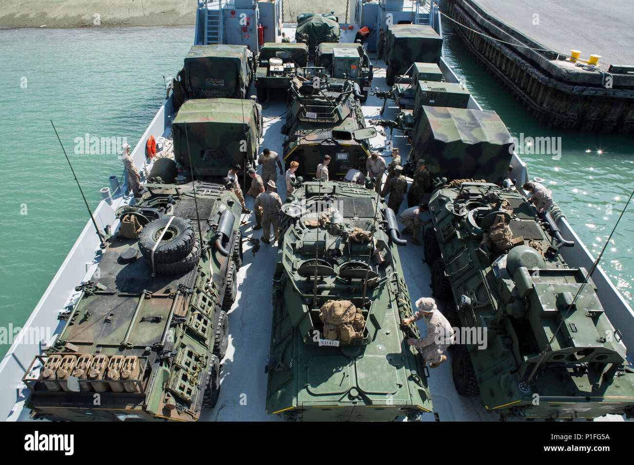 U.S. service members load Humvees onto the USAV Harpers Ferry ...