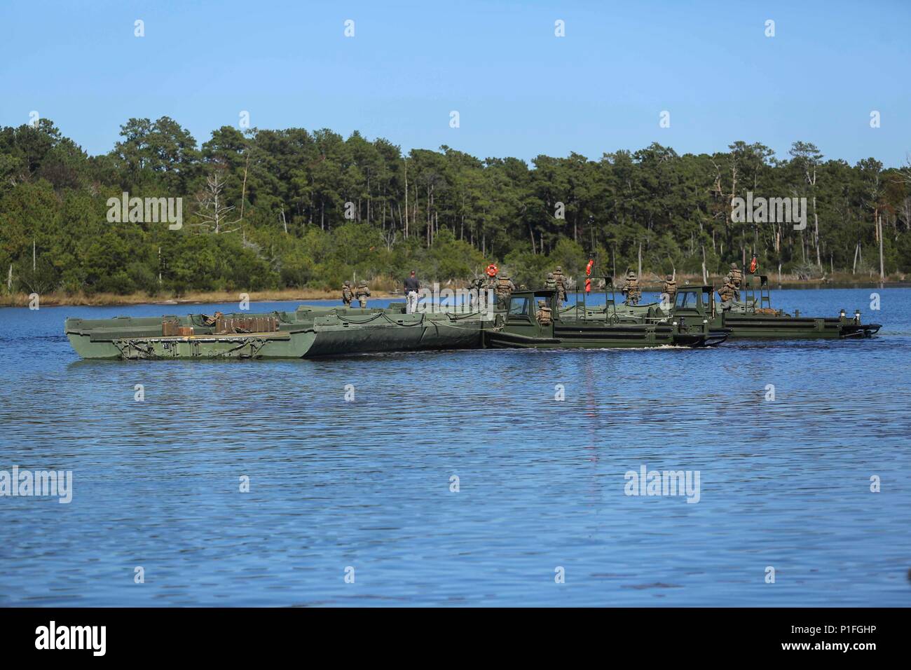 Marines link pieces of an improvised ribbon raft together to create a ...