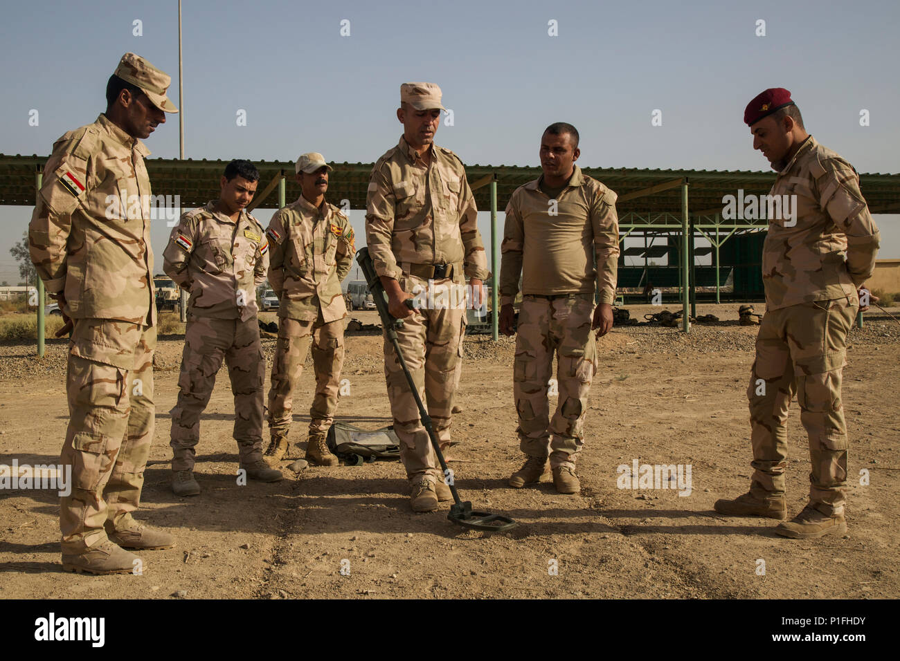Iraqi soldiers from the 3rd Iraqi Army Brigade use a metal detector to ...
