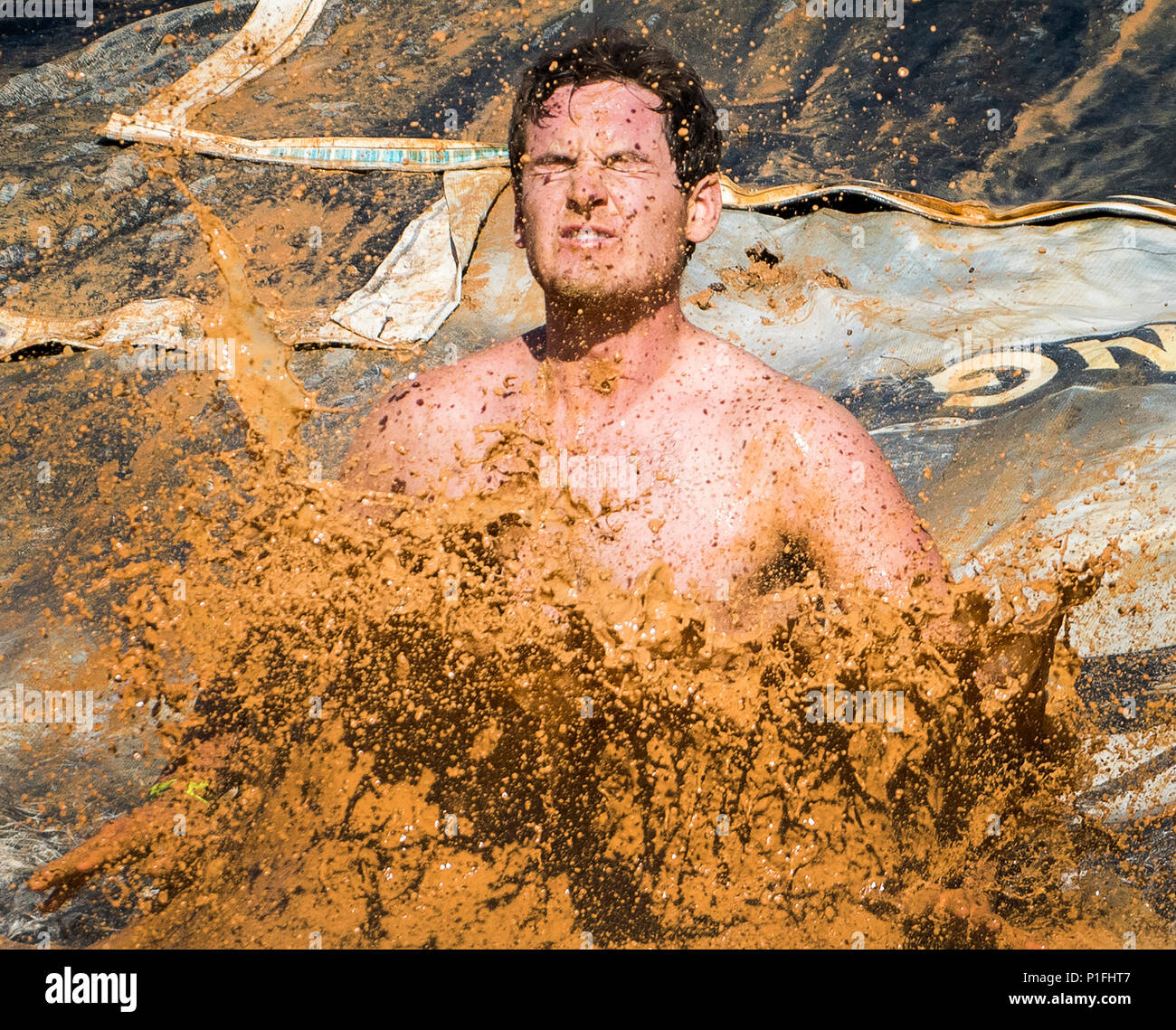 A competitor braces for a muddy impact at the finish of the Pensacola ...