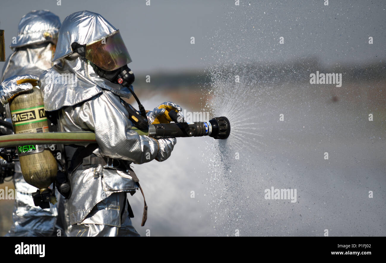 A 2nd Civil Engineer firefighter fires up his hose during an aircraft ...