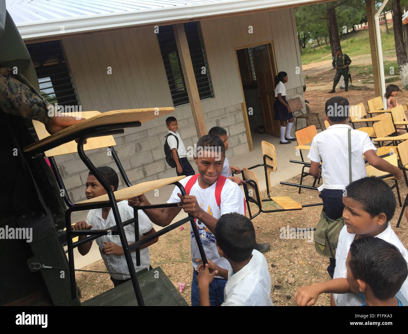 School children from Puerto Lempira help unload brand new school desks ...