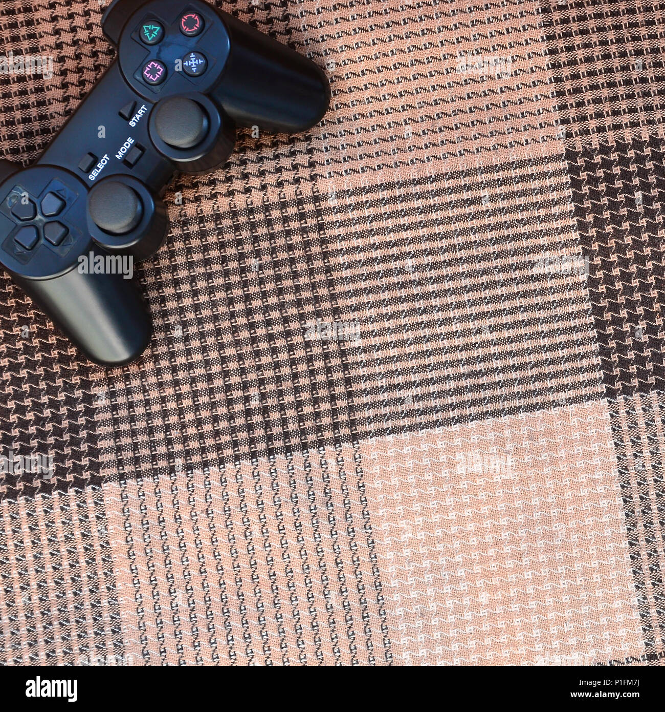 The video game controller from the game console is on the checkered ...