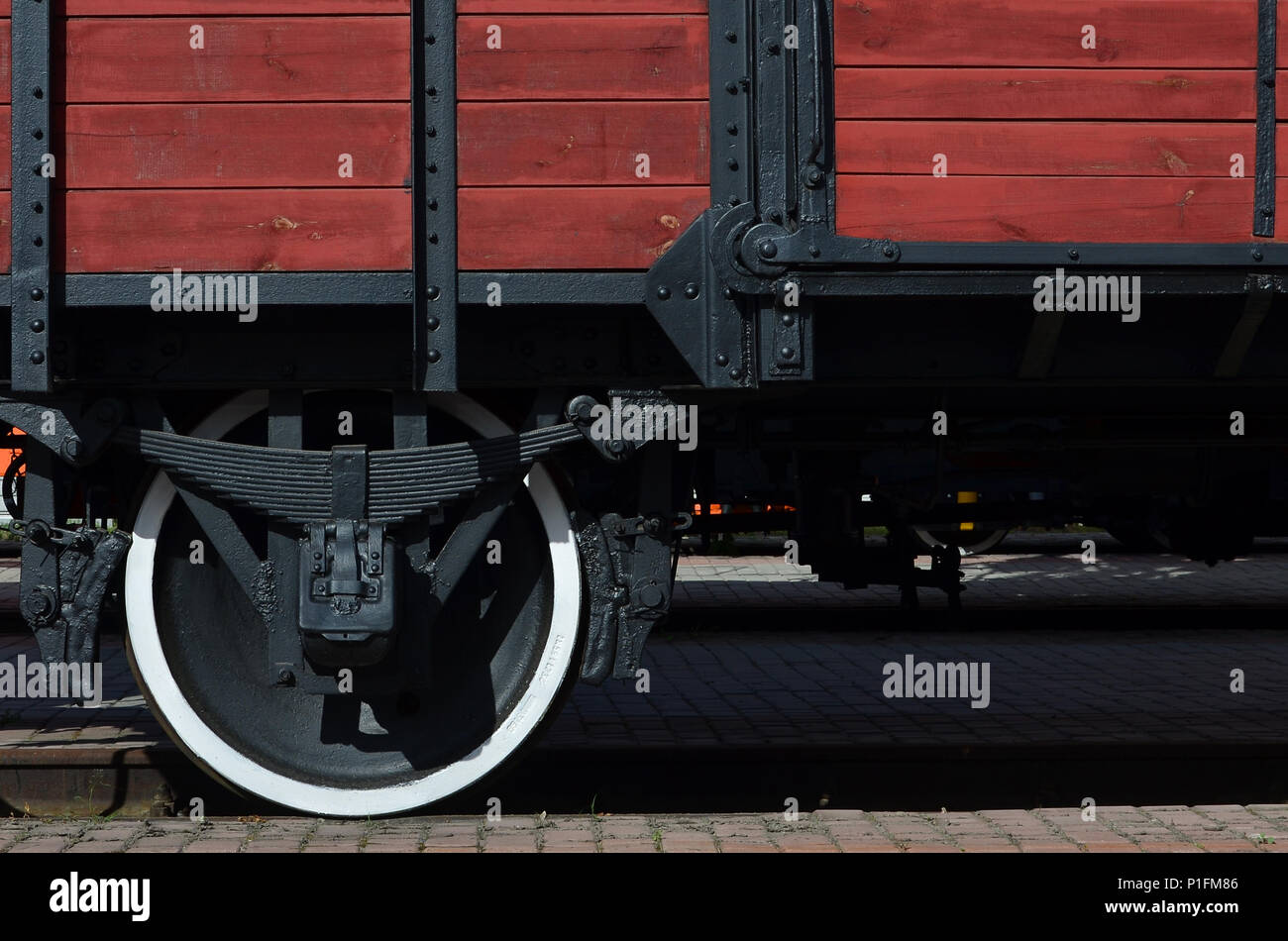 The side of the old brown wooden freight car with the wheel of the ...