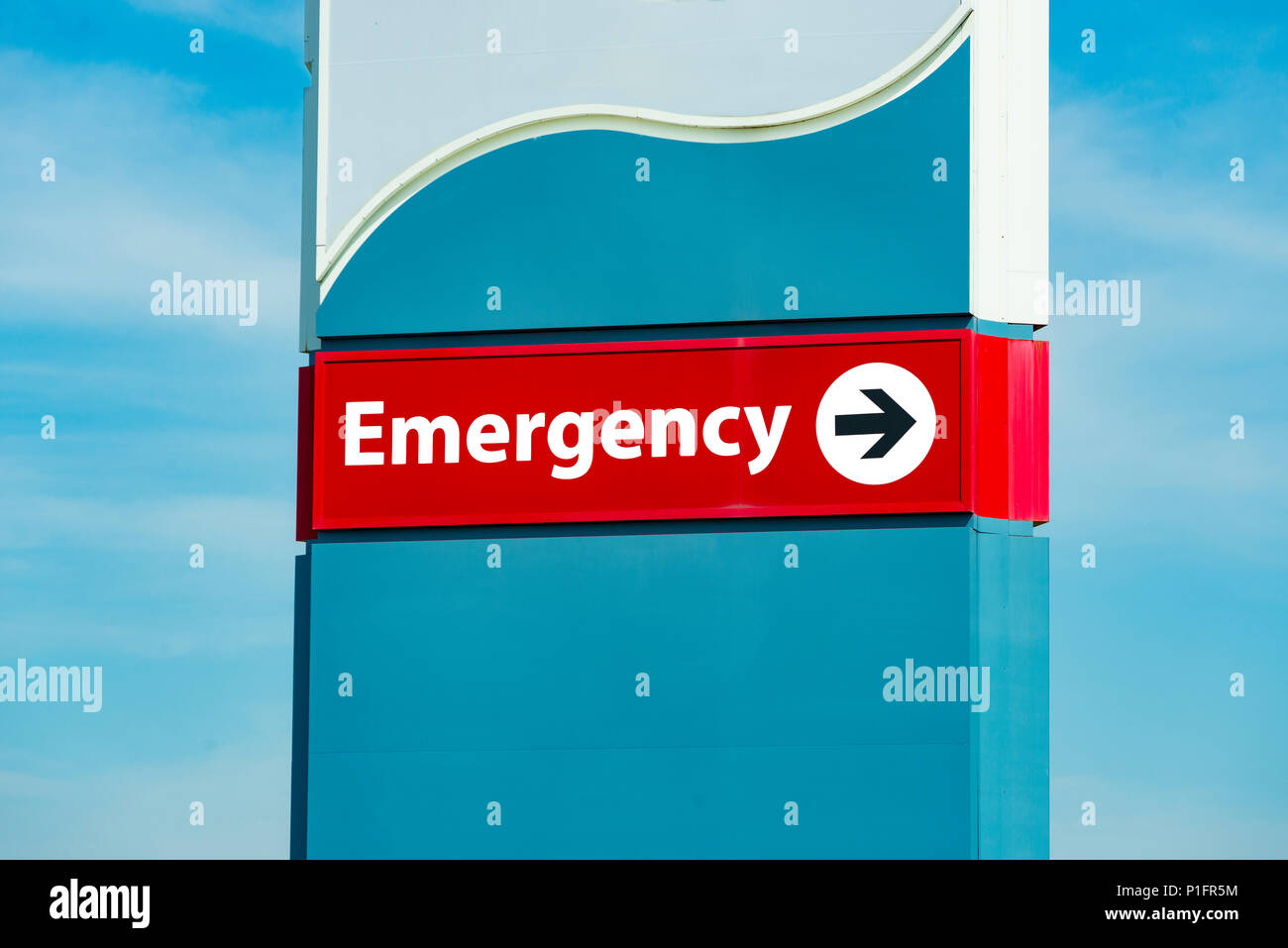 Horizontal close-up shot of a hospital emergency room sign. Cloudy sky ...