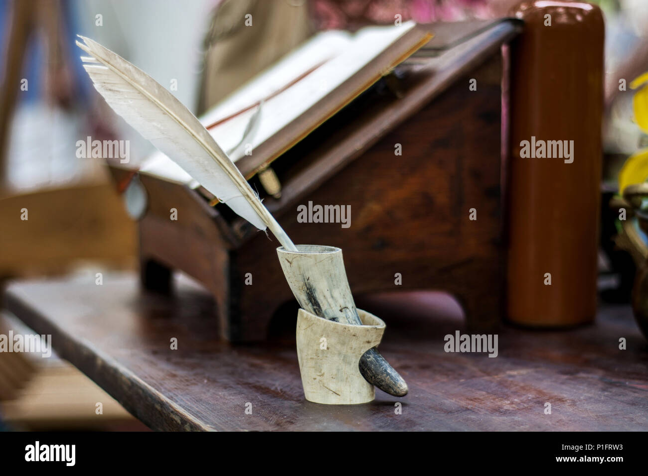 Medieval quill pen for writing in inkwell from horn on wooden desk ...