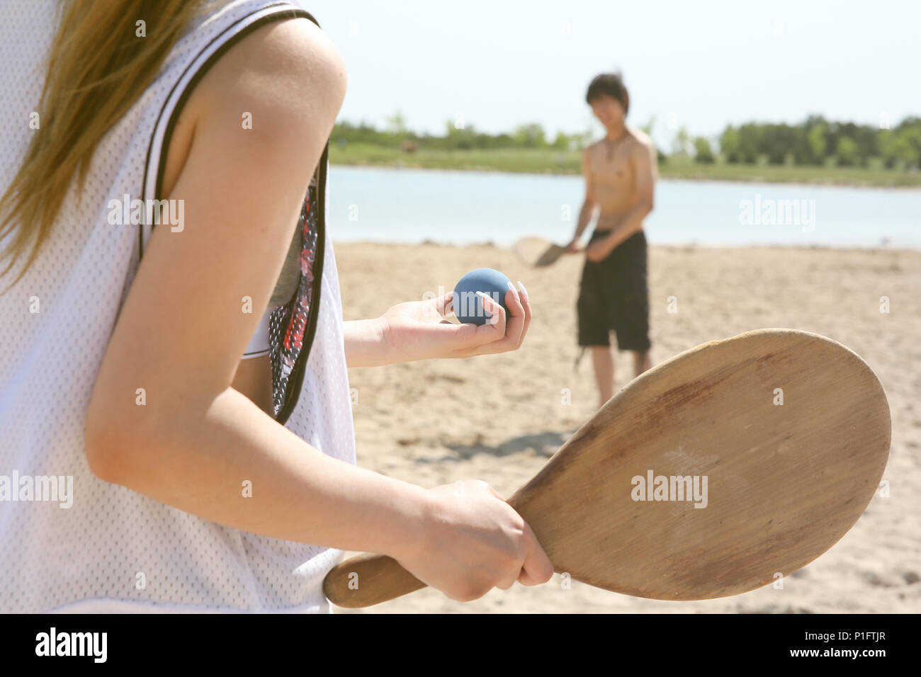 Friends playing fresco ball at the Beach in a sunny day. Summer time ...