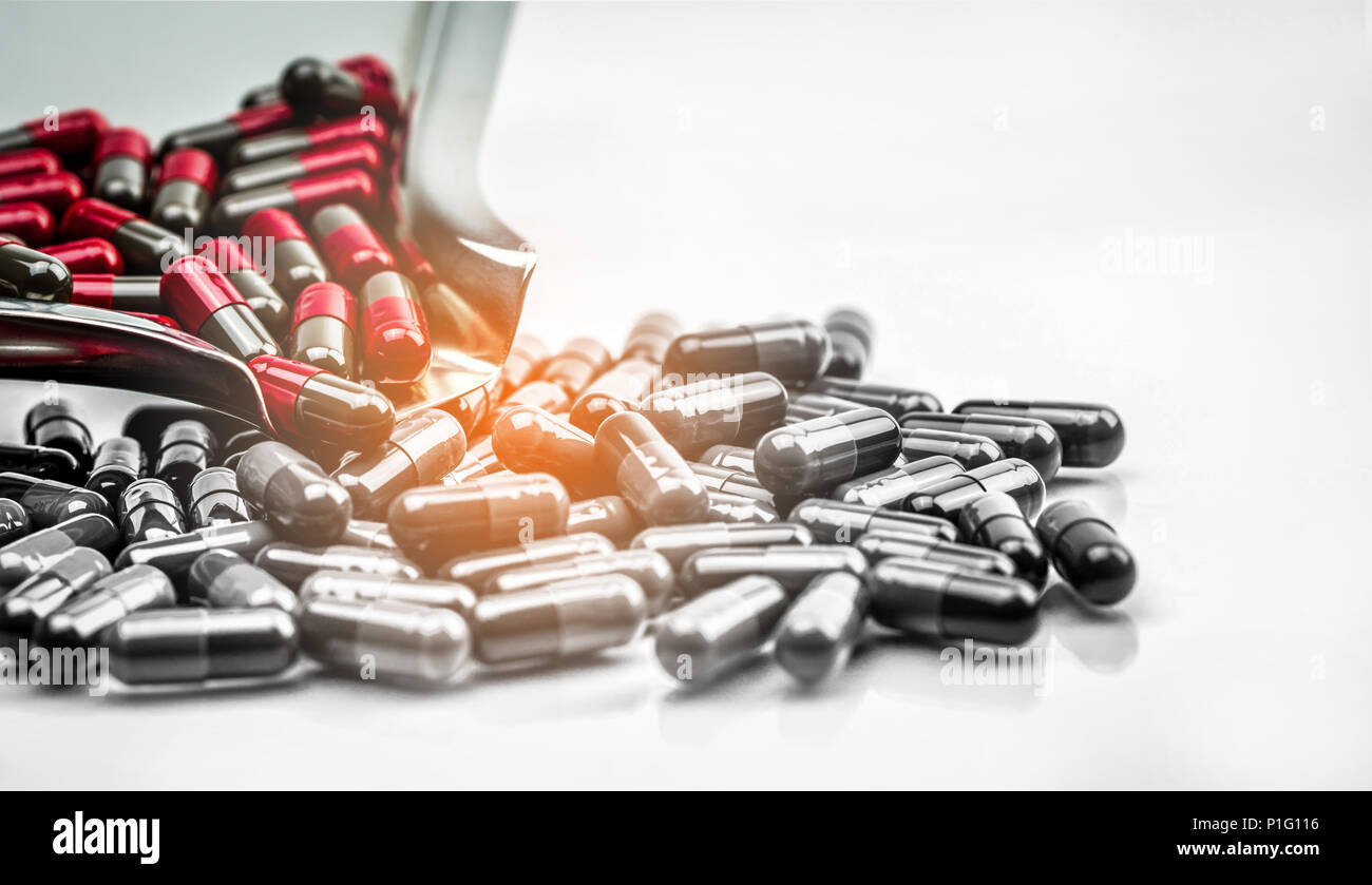 Red and grey capsule pills on stainless steel drug tray and gray ...
