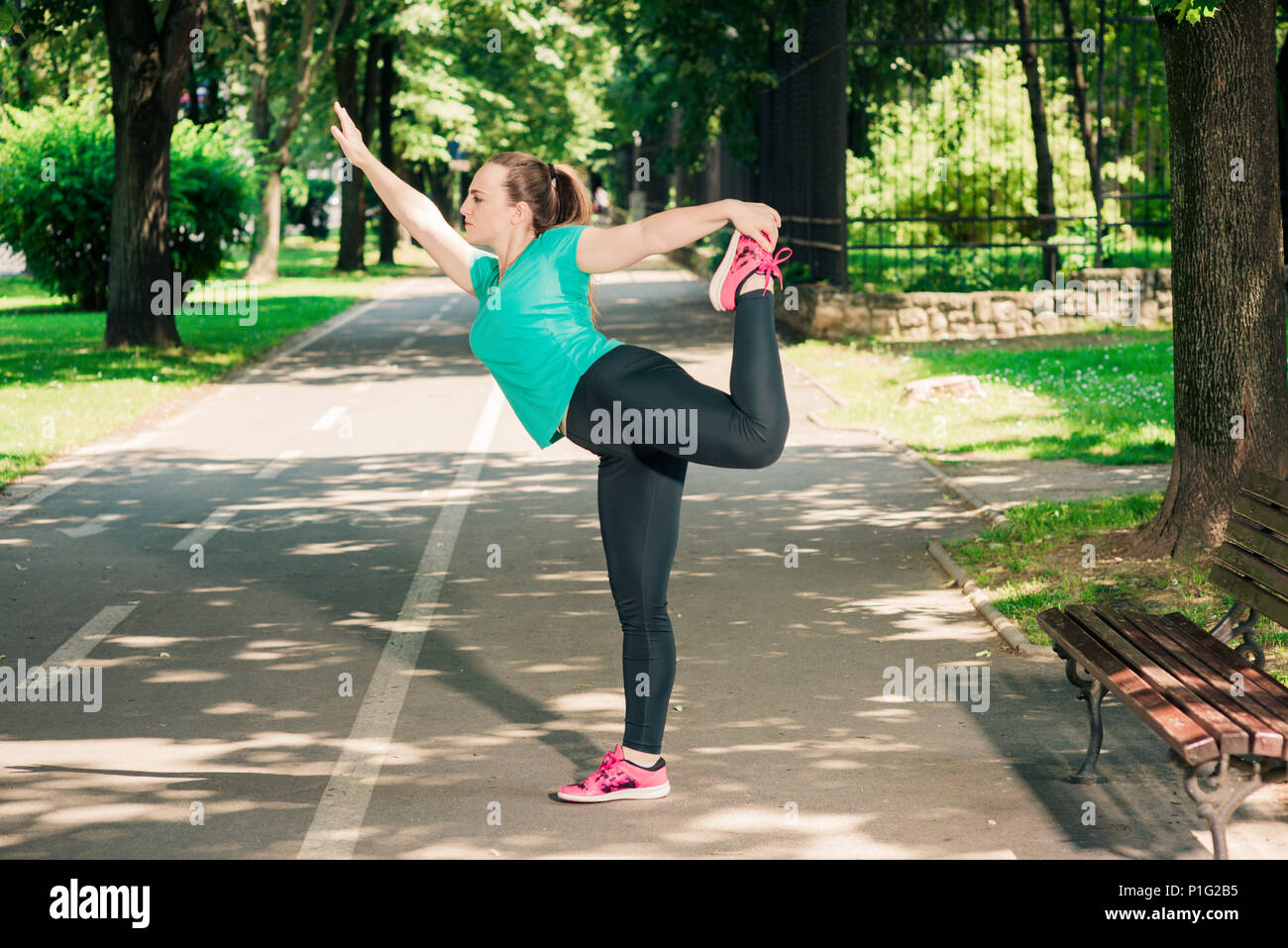 Flexible young woman stretching her left leg Stock Photo - Alamy