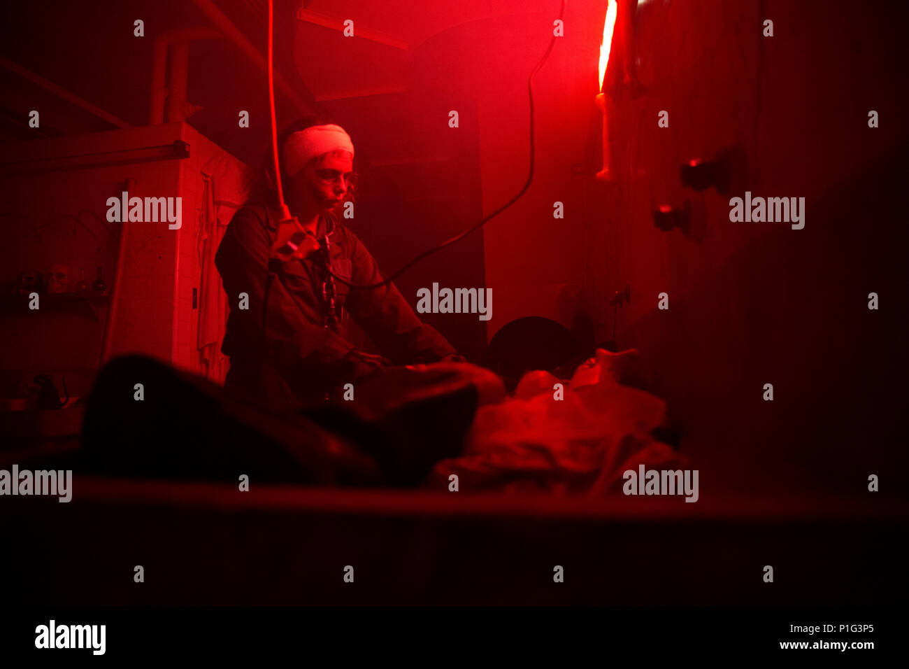 An actor pretends to dismember a victim on an operating table in the ...