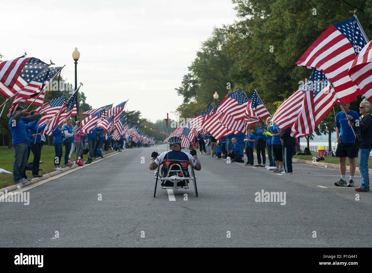 A hand cyclist passes the 11th-mile marker of the Marine Corps Marathon ...