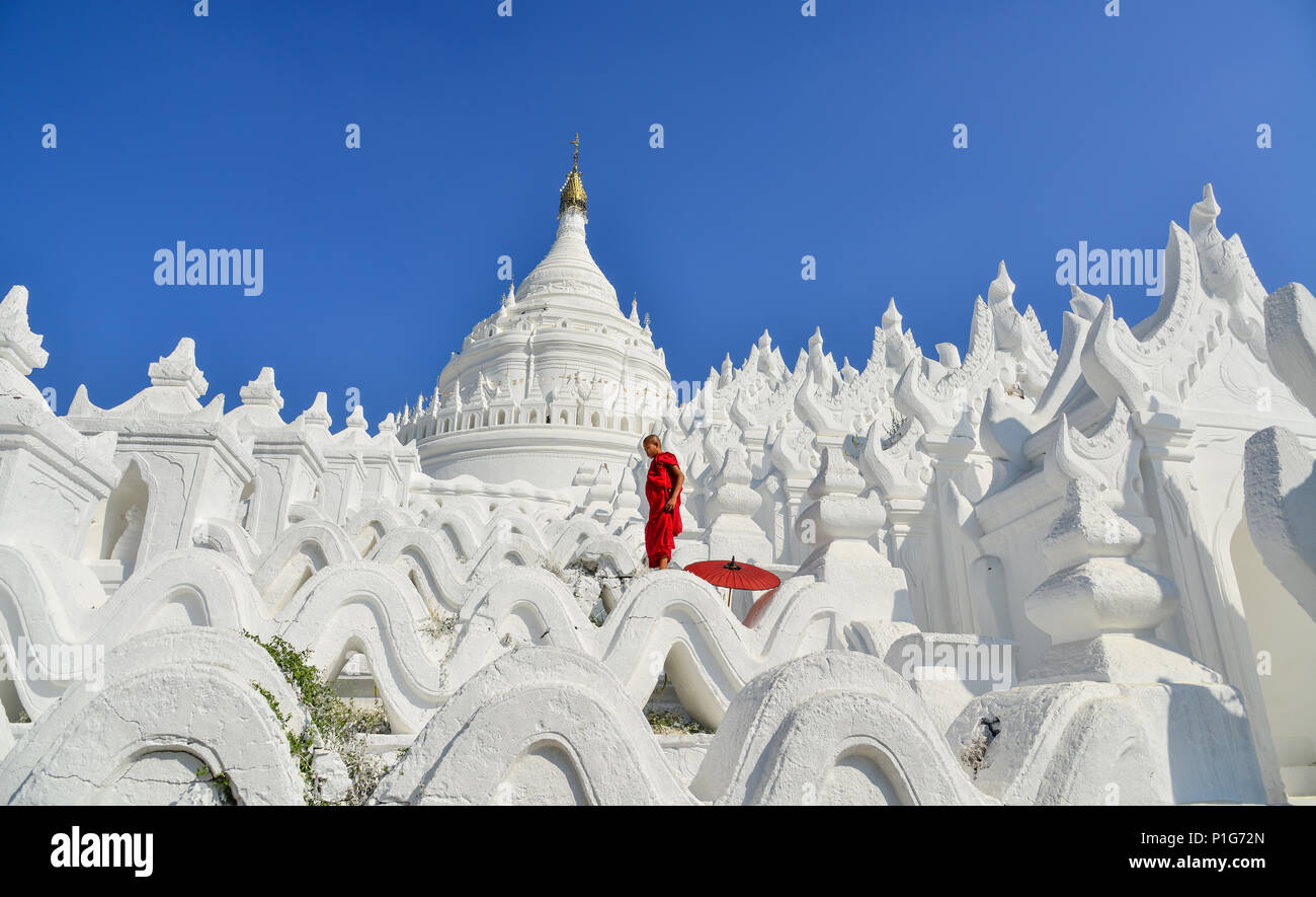 A Buddhist novice monk playing on steps of the white temple Stock Photo ...