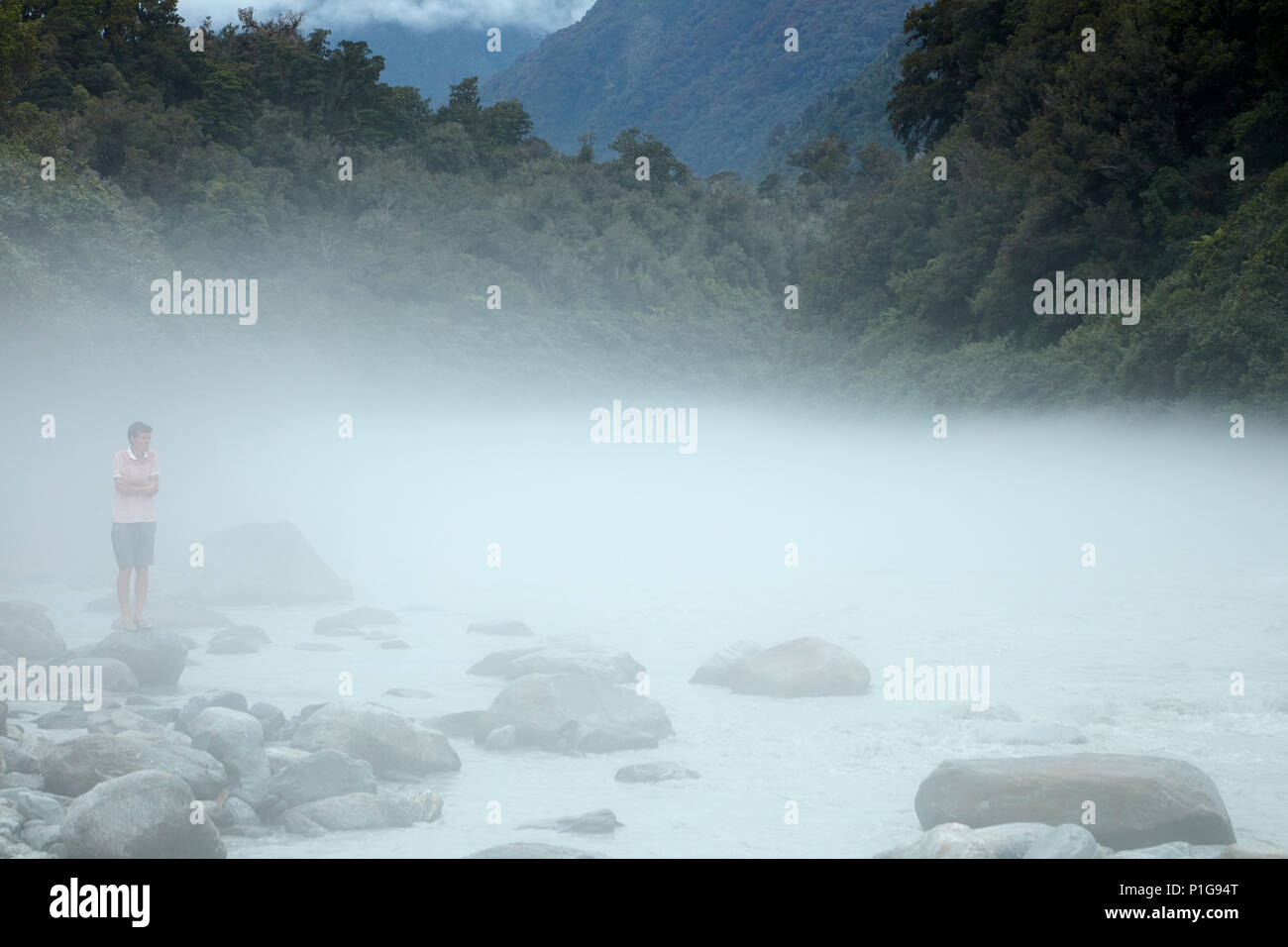 Tourist and mist over Cook River, near Fox Glacier, West Coast, South ...