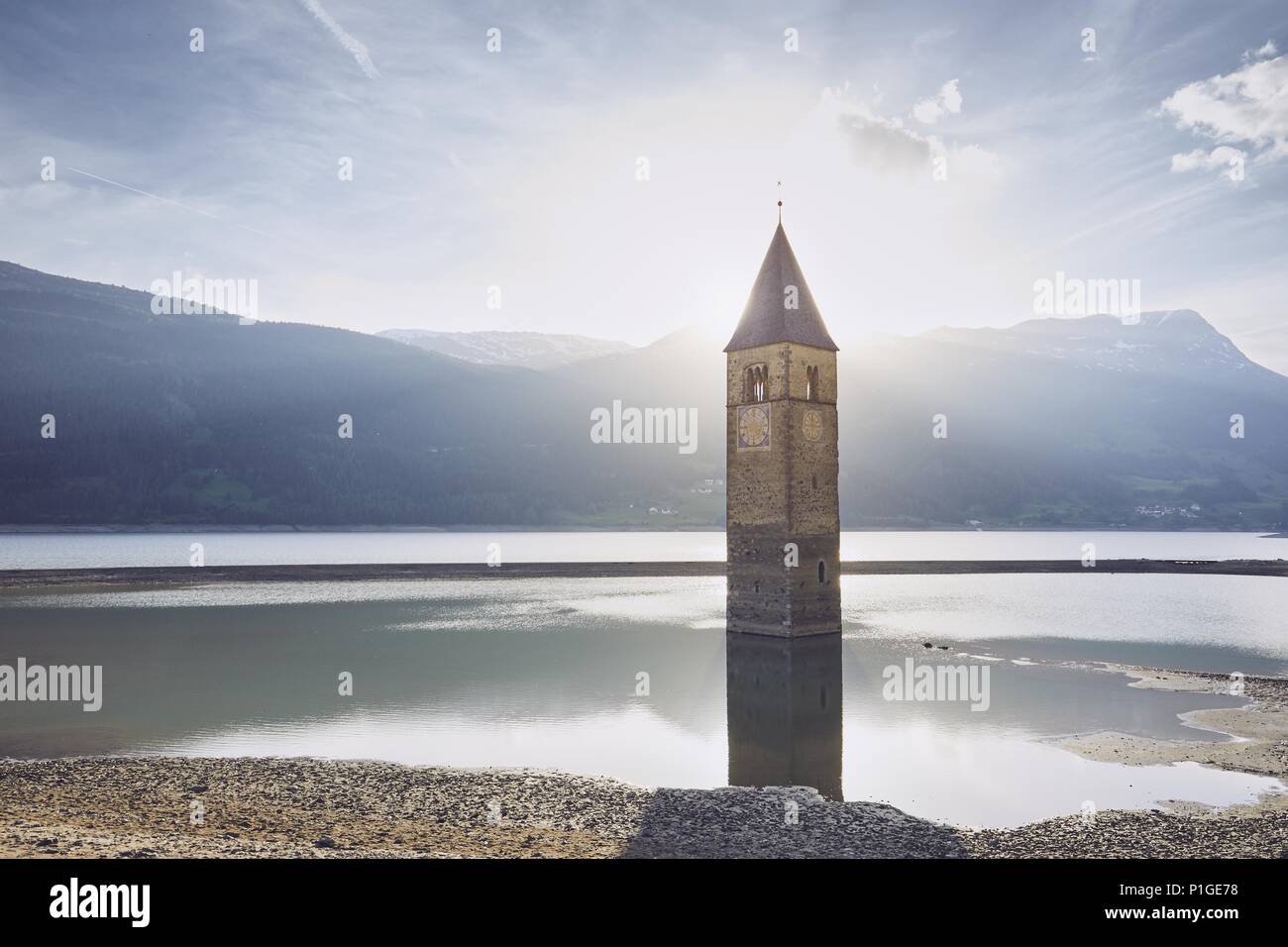 Old church tower in water at sunset. Resia Lake (Lago di Resia or ...