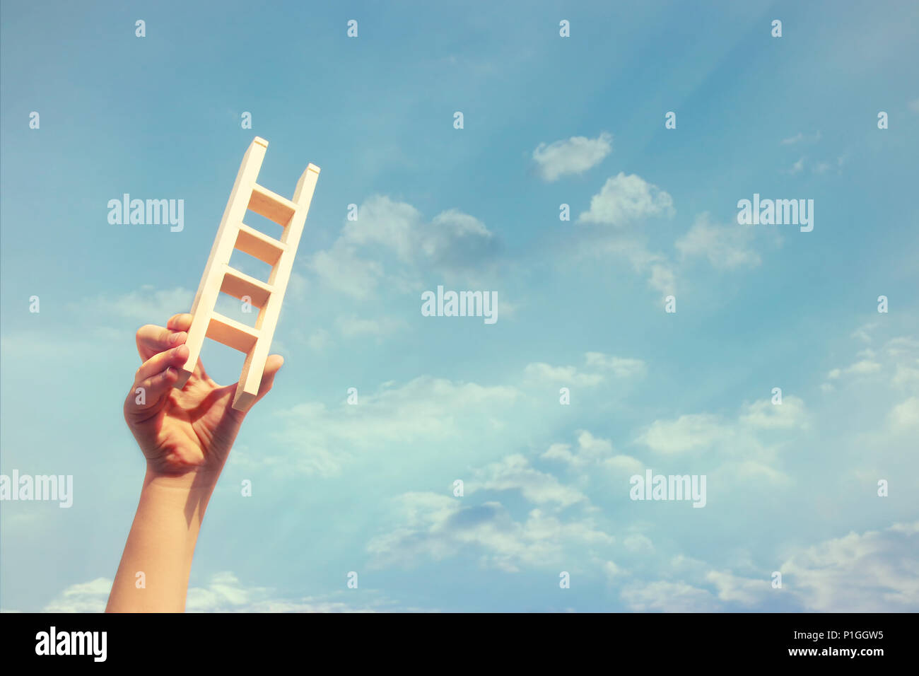 image of child hand holding a ladder against the sky. education and ...
