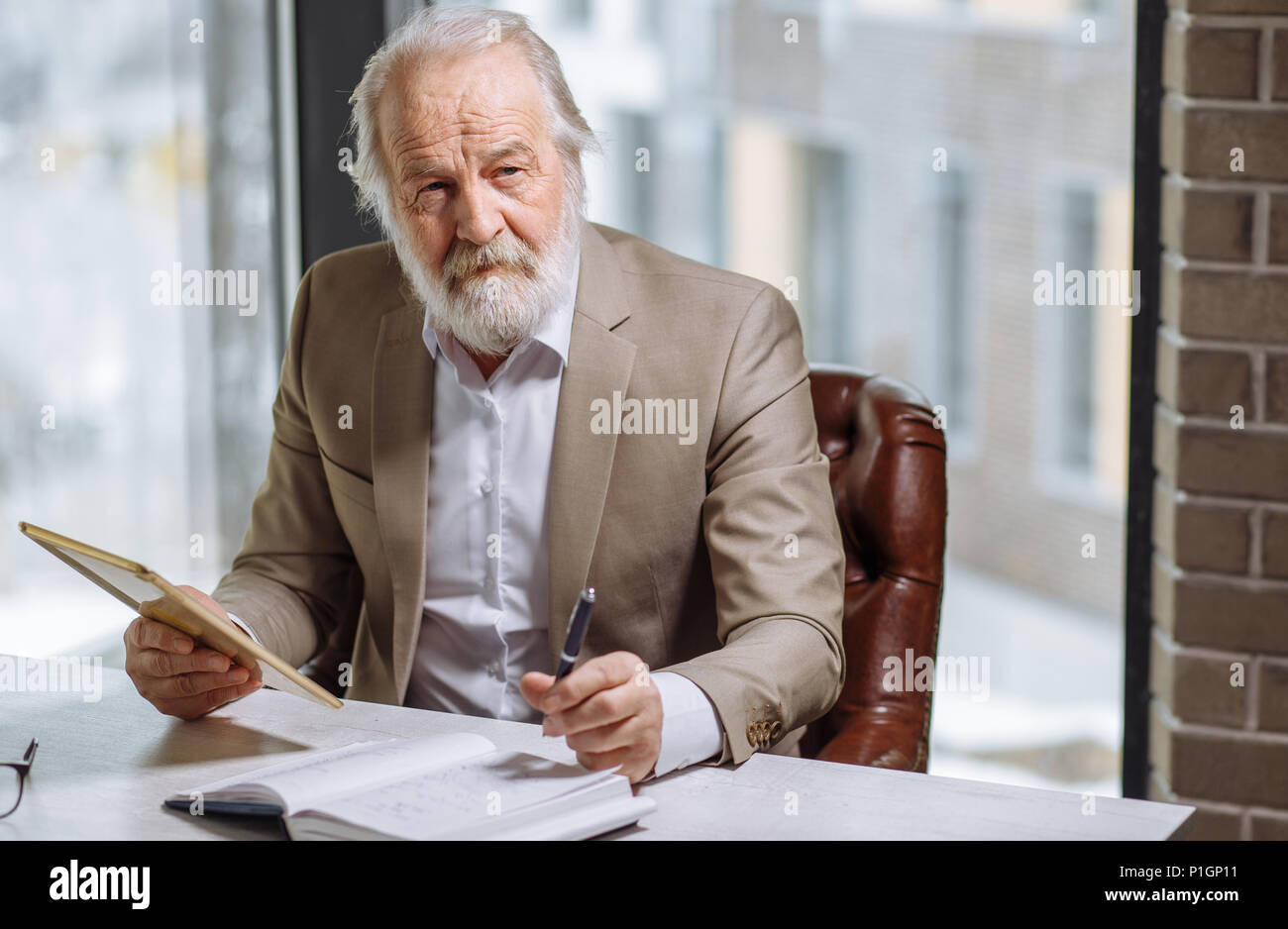 handsome thinking grey headed man wearing white shirt and cream suit ...