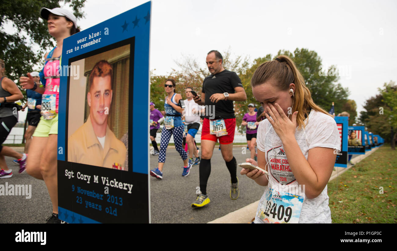 A runner pauses at a memorial poster during the Marine Corps Marathon ...