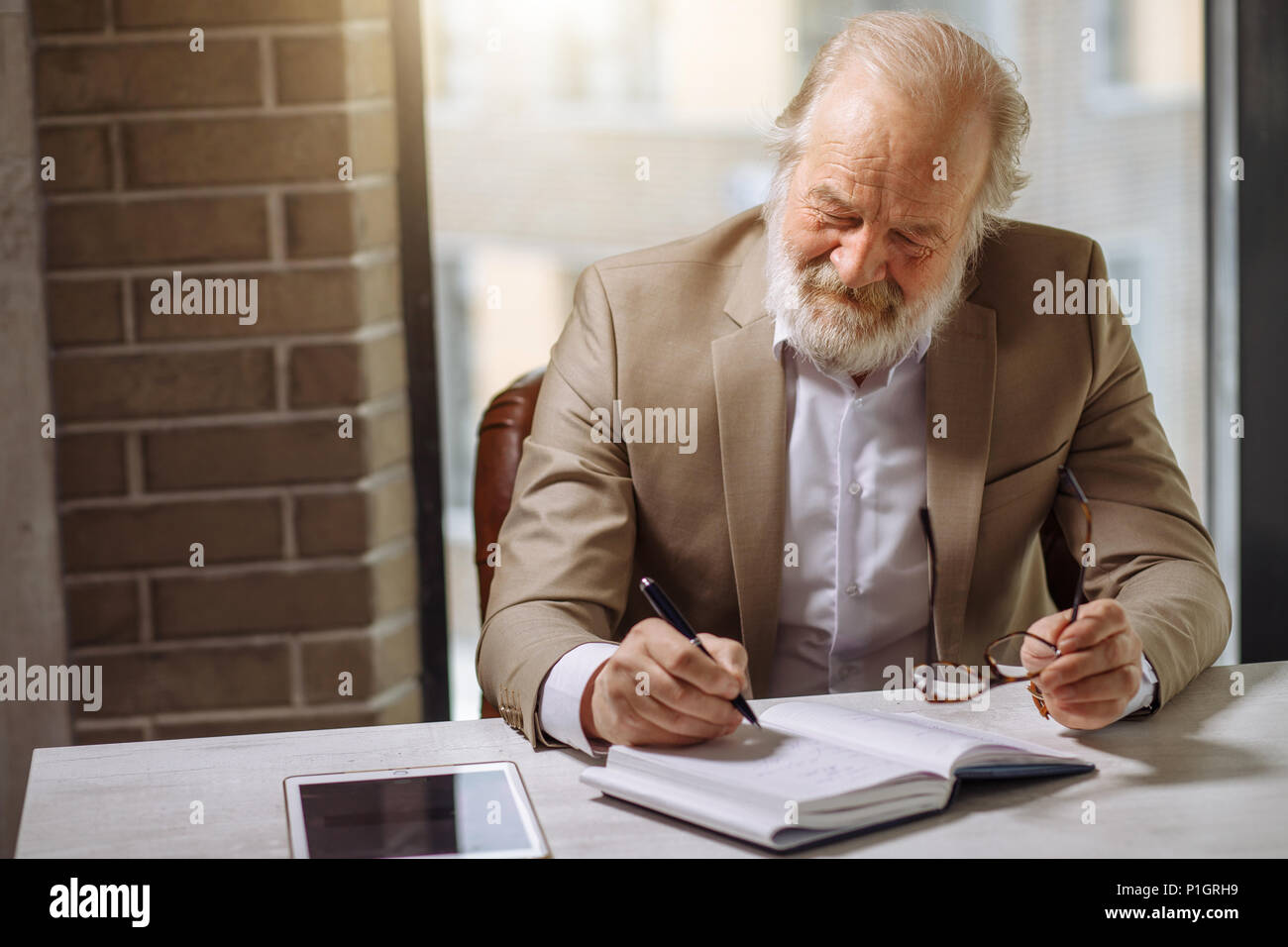 handsome old man recording his observationsin a notebook Stock Photo ...