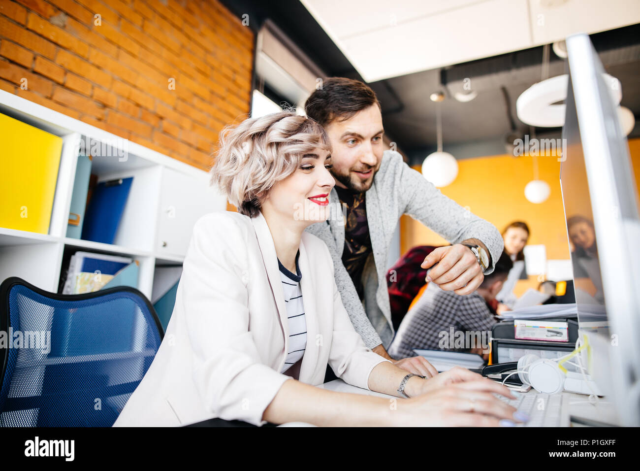 two young attractive employees are looking at the funny photos on the ...