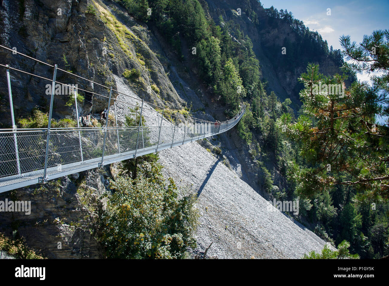 Suspension bridge traversing a sheer rock face in the Swiss Alps ...