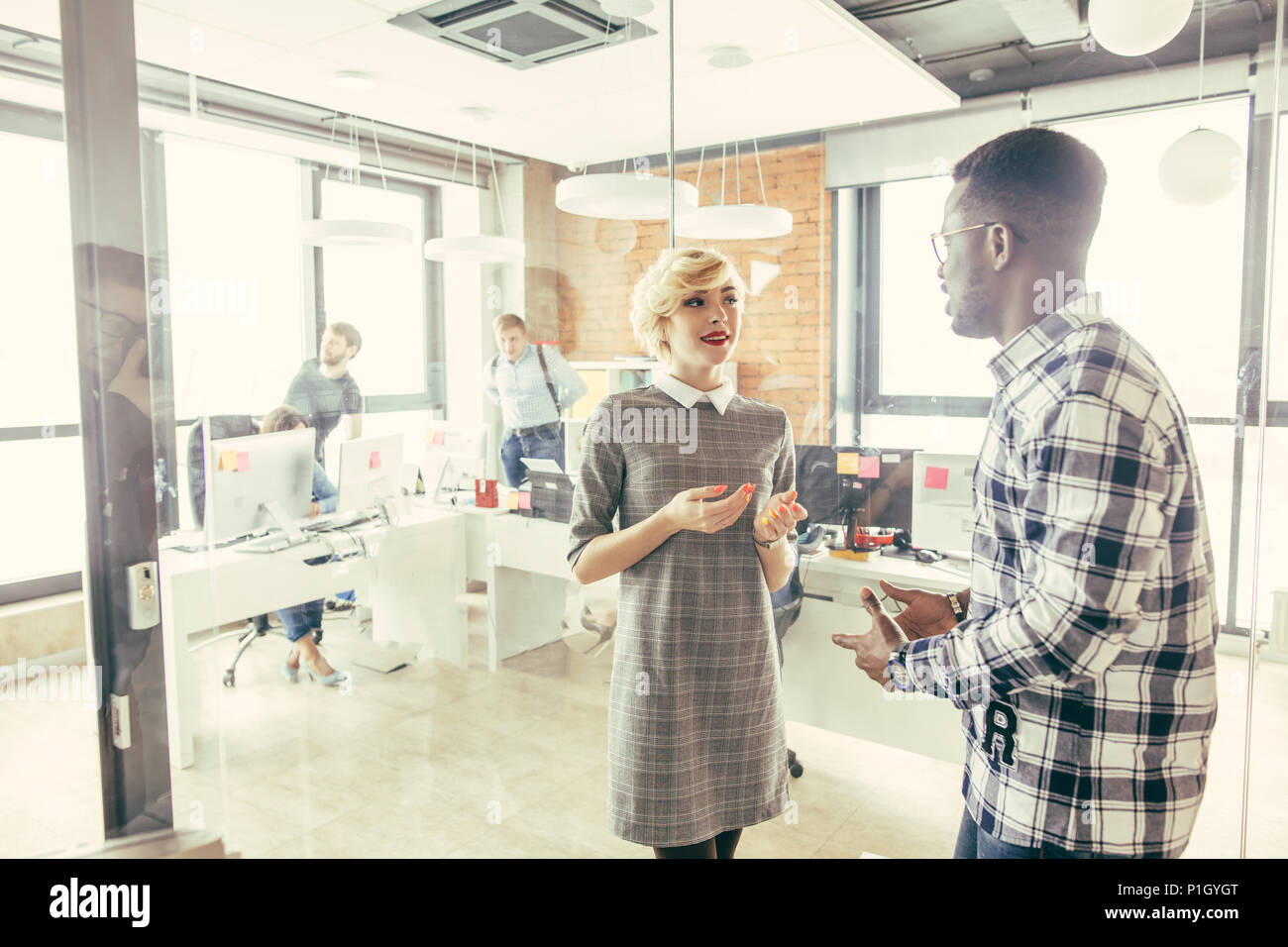 young good-looking female leader giving an indication for a trainee ...