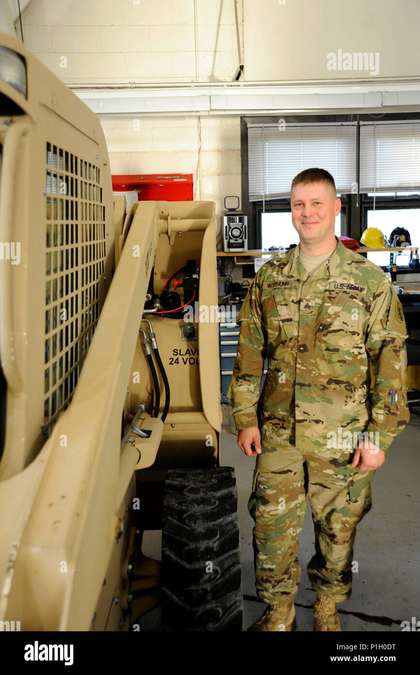 Sgt. Scott Witthuhn poses next to a skid steer loader installed with ...