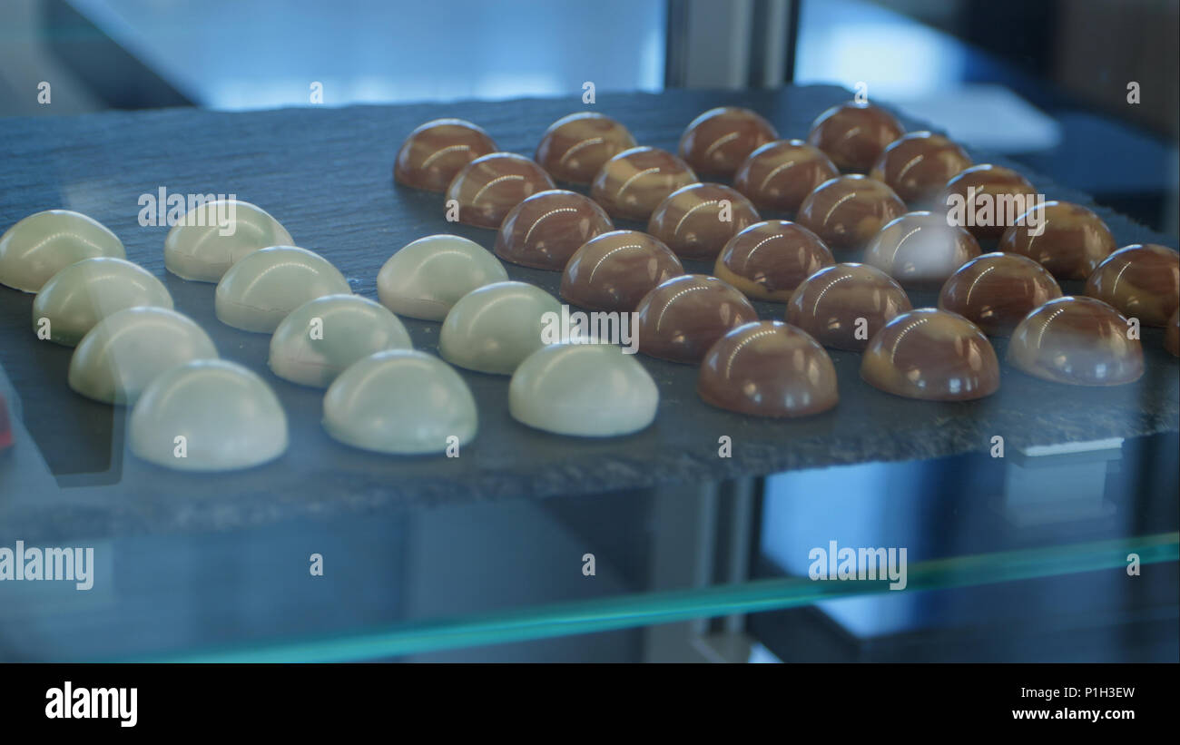 Chocolate and white chocolate candies in shop window Stock Photo - Alamy