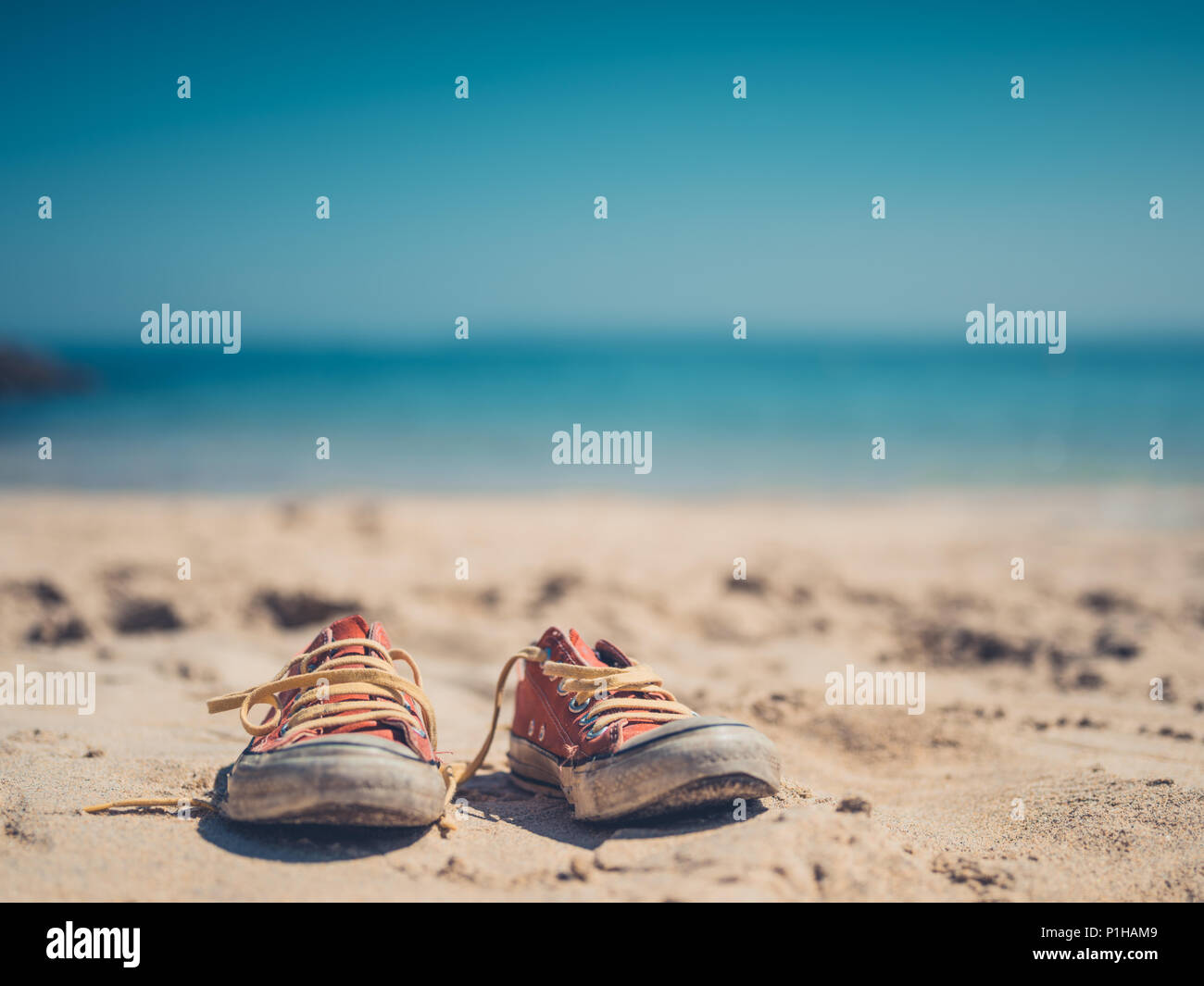 A pair of sneakers on the beach Stock Photo - Alamy