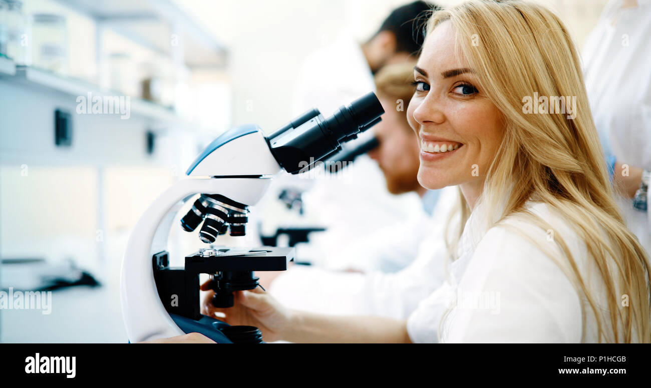 Young scientist looking through microscope in laboratory Stock Photo ...